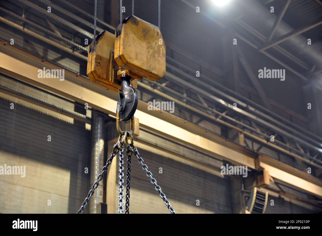 Lifting mechanism in the workshop at the plant. Crane hook and chains ...