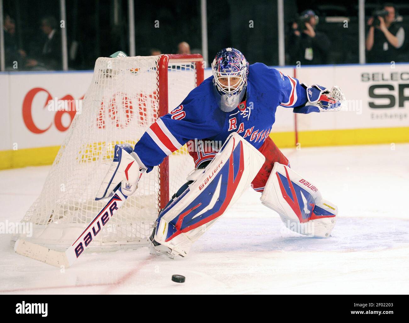 Goalie Henrik Lundqvist of the New York Rangers turns away a shot ...