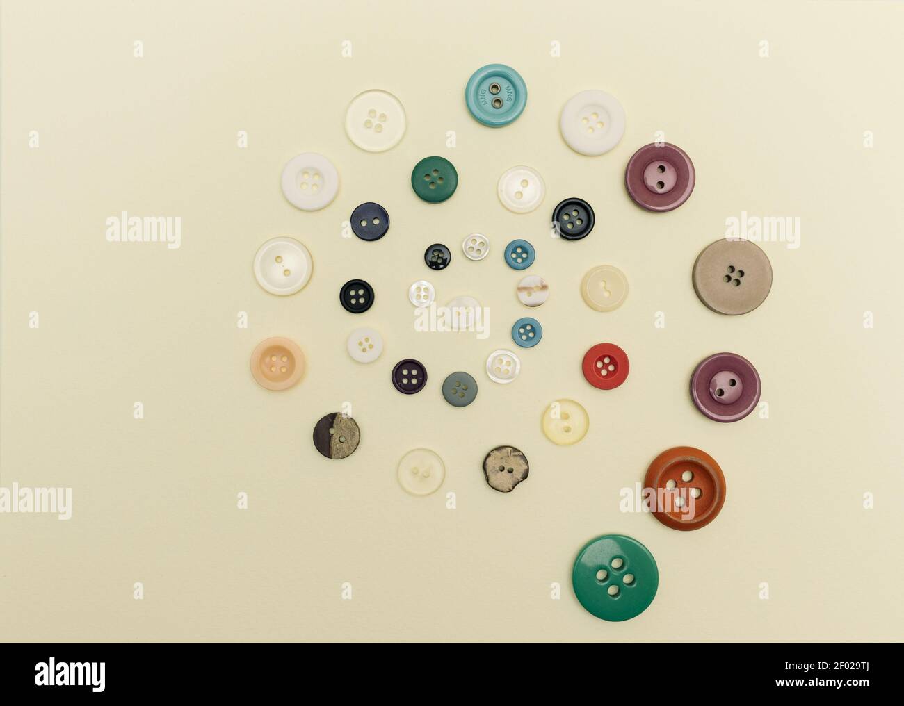 Colorful buttons layed out in a spiral on a beige background. Creative ...
