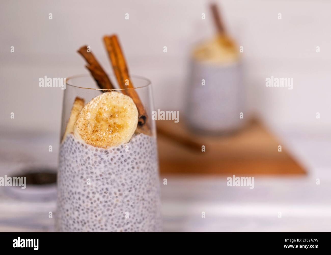 Chia seeds pudding with banana, cinnamon and yougurt on white wooden ...