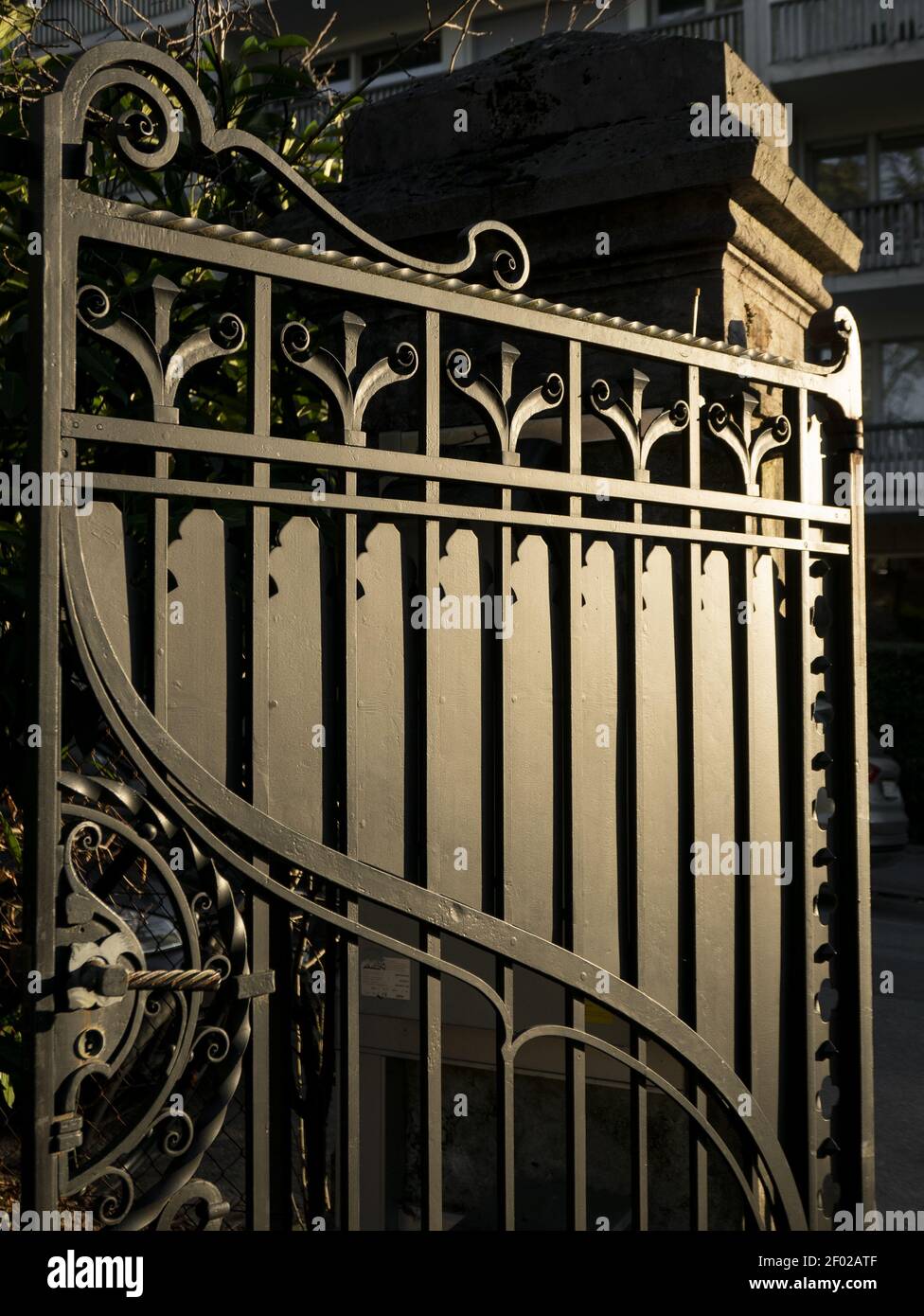 A vertical closeup shot of a metal gate in front of a building Stock ...