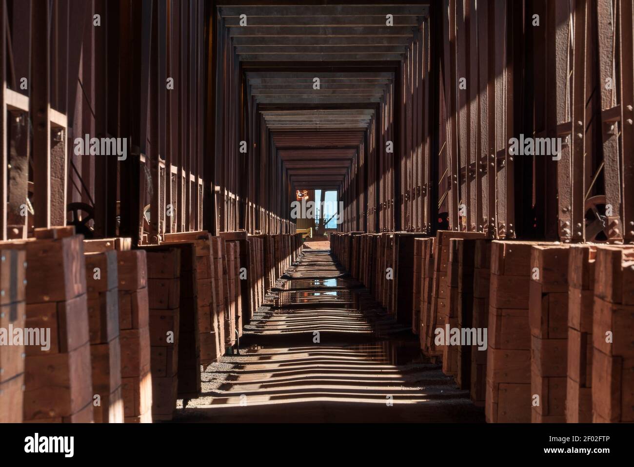 A long corridor in the industrial building with shadows of the columns ...