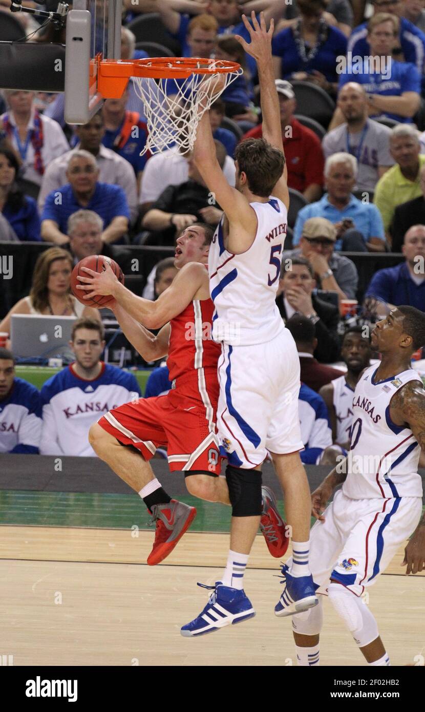 Aaron Craft (4) of Ohio State is defended by Jeff Withey (5) of Kansas ...
