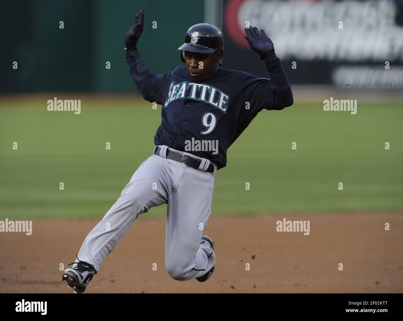 The Seattle Mariners' Chone Figgins slides into third base after ...