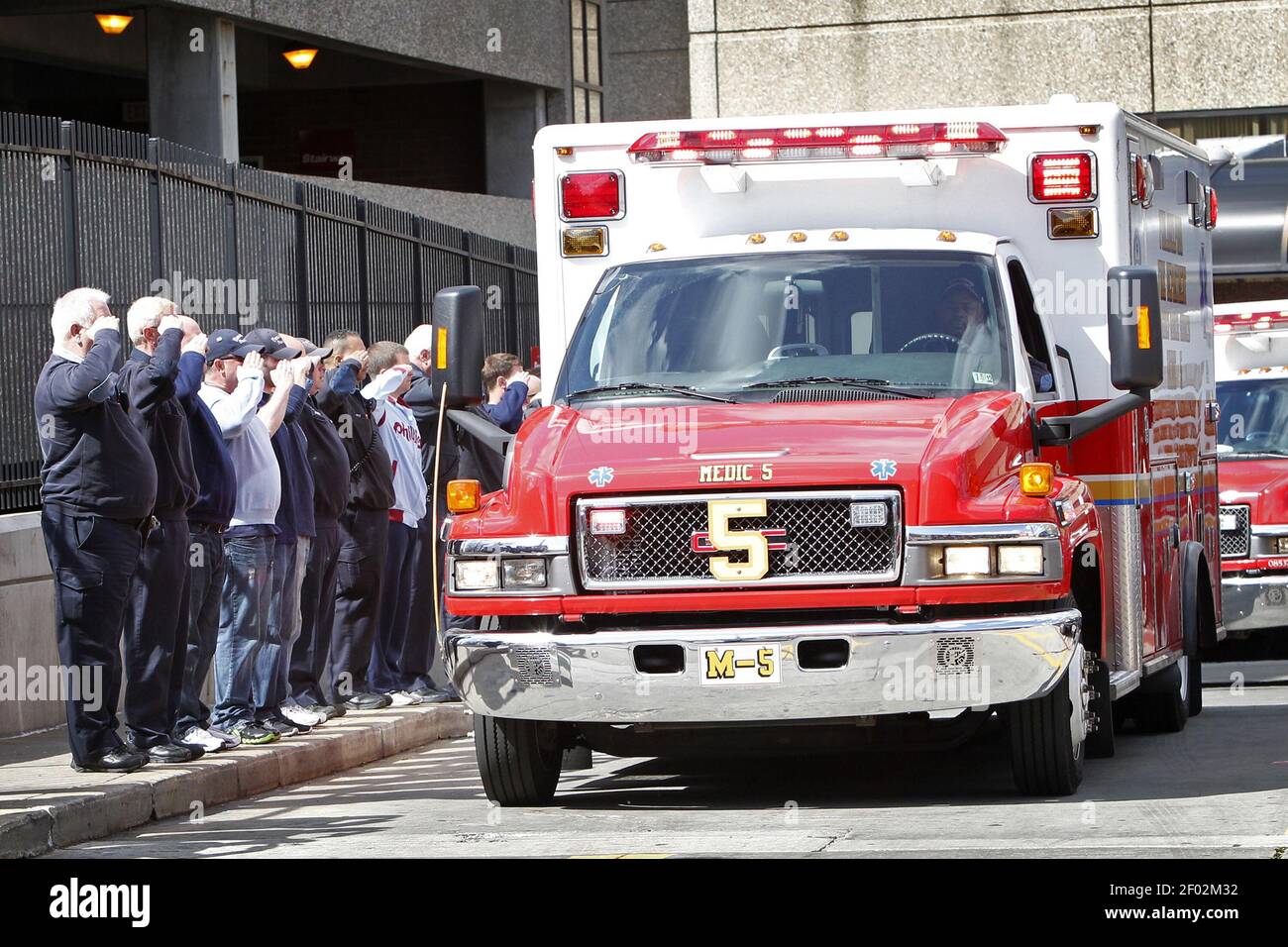 Off duty fire fighters salute as the bodies of their fellow firemen are ...