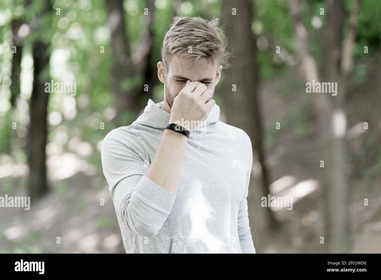 Pain after workout. Man jogger stop running in park because of headache ...