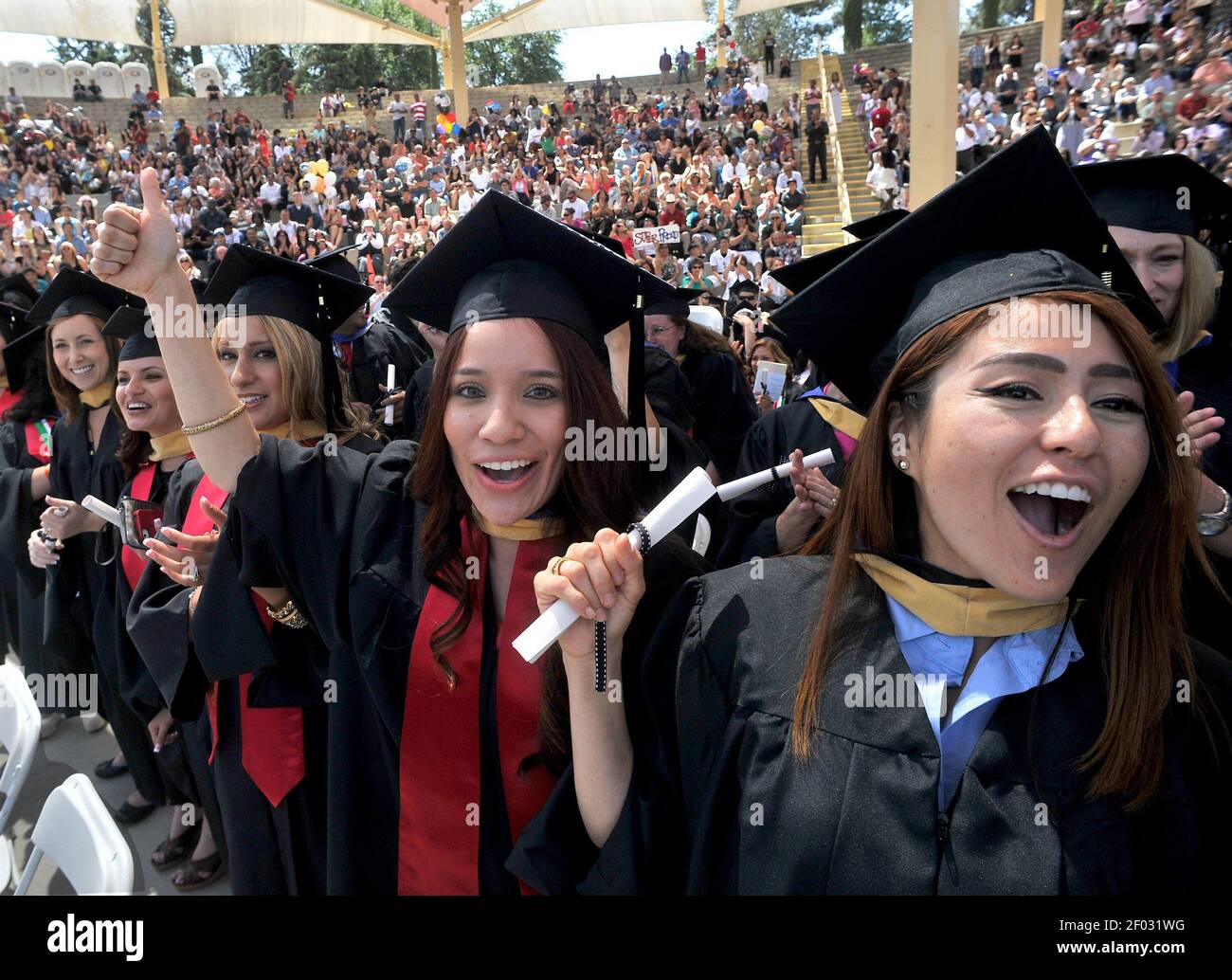 New grads Cynthia Guzman, right, and Erica Ochoa, center, celebrate at ...