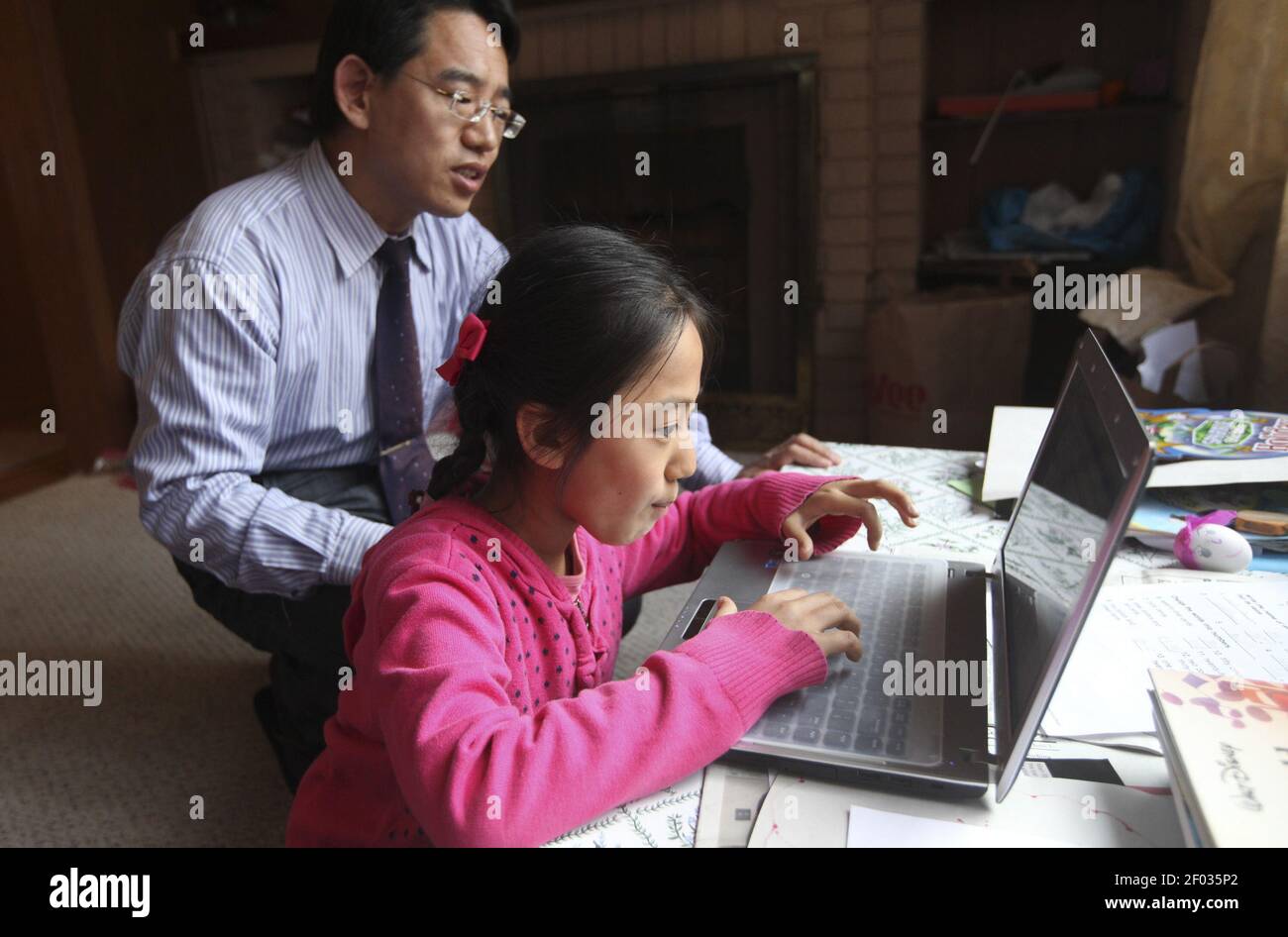 Zhengjun Wang watches as his eight-year-old daughter Qiaoyu Wang looks ...