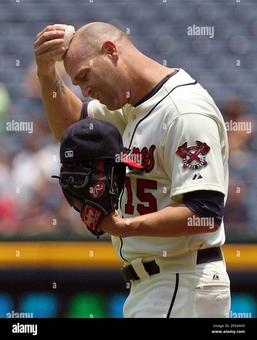 Atlanta Braves pitcher Tim Hudson uses a rosin bag to powder his head ...