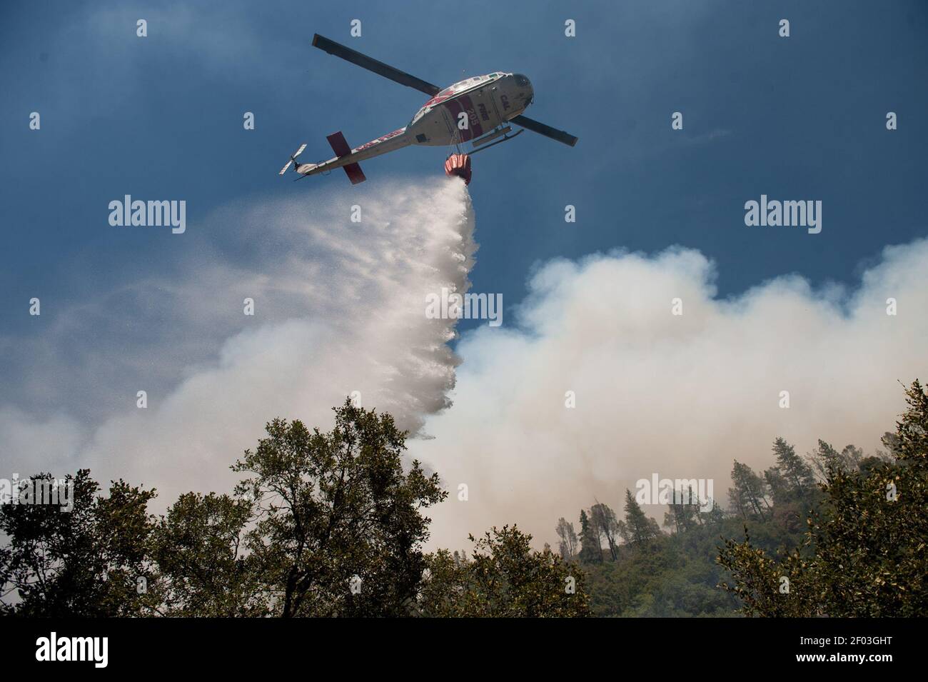 A Cal Fire helicopter makes a water drop next to Yankee Jim's Road in ...