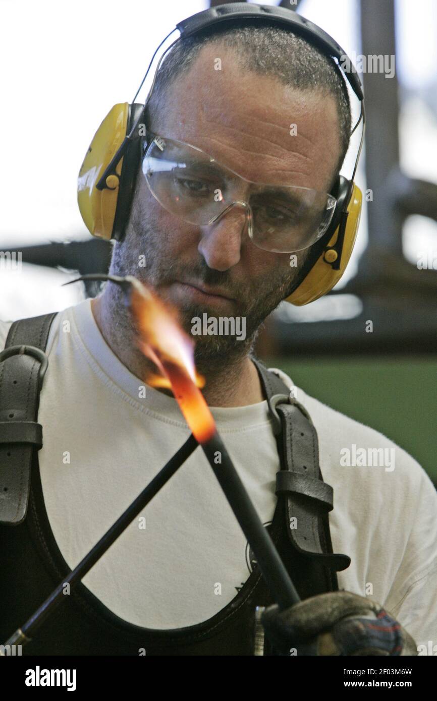 Israeli blacksmith Amit Har-lev heats up a metal rod that he will shape ...