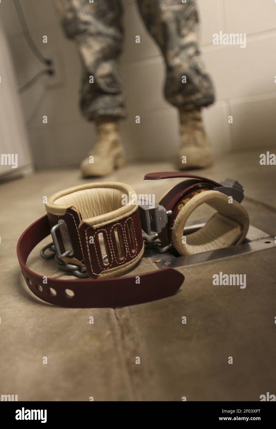 An Army officer shows the leg shackles that may be used at the camps at ...