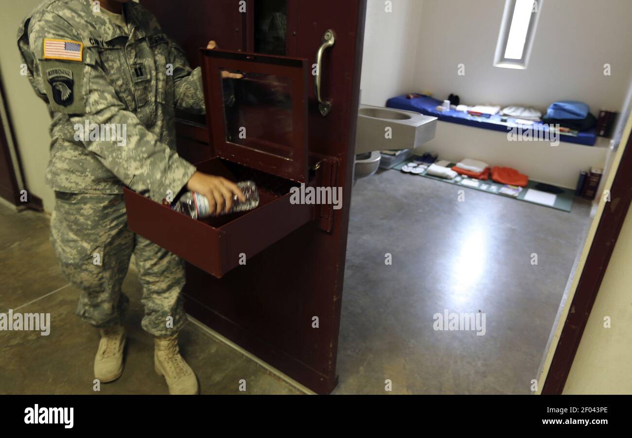 An Army officer demonstrates the pass through door on one of the cells ...