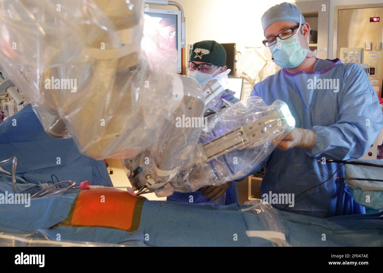 Dr. Mark Pozsgay, right, adjusts an instrument on the daVinci Surgical ...