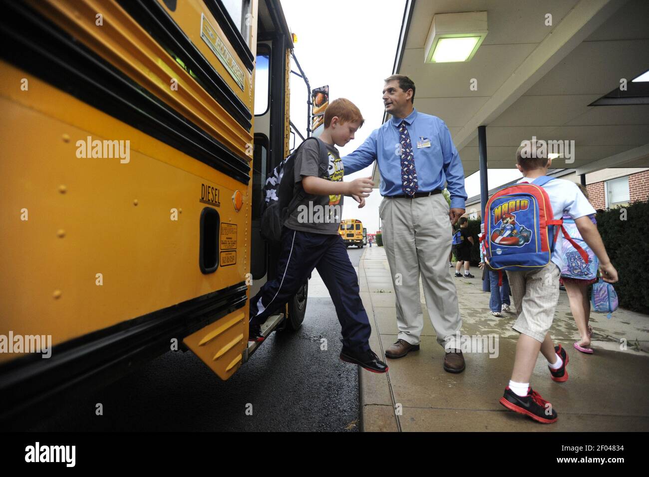Principal James Orichosky greets children as they come off the buses ...