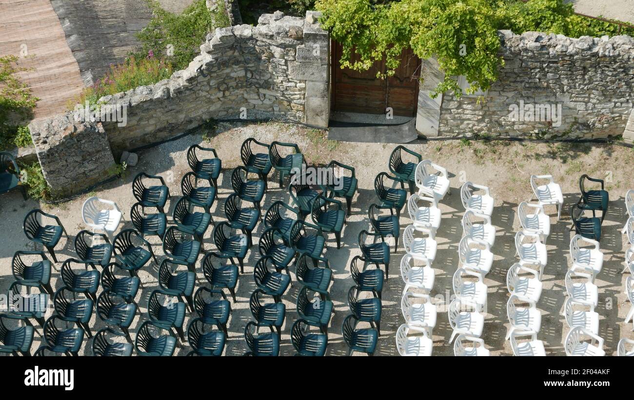 A high angle shot of chairs lined up next to each other in a garden ...