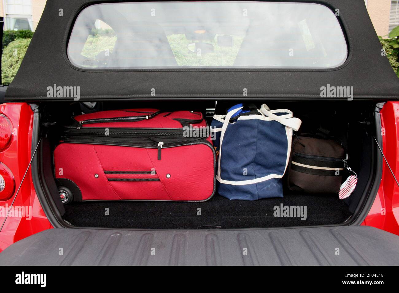 Stowed in the back of the Smart Car are a 22-inch roll-abourd suitcase ...