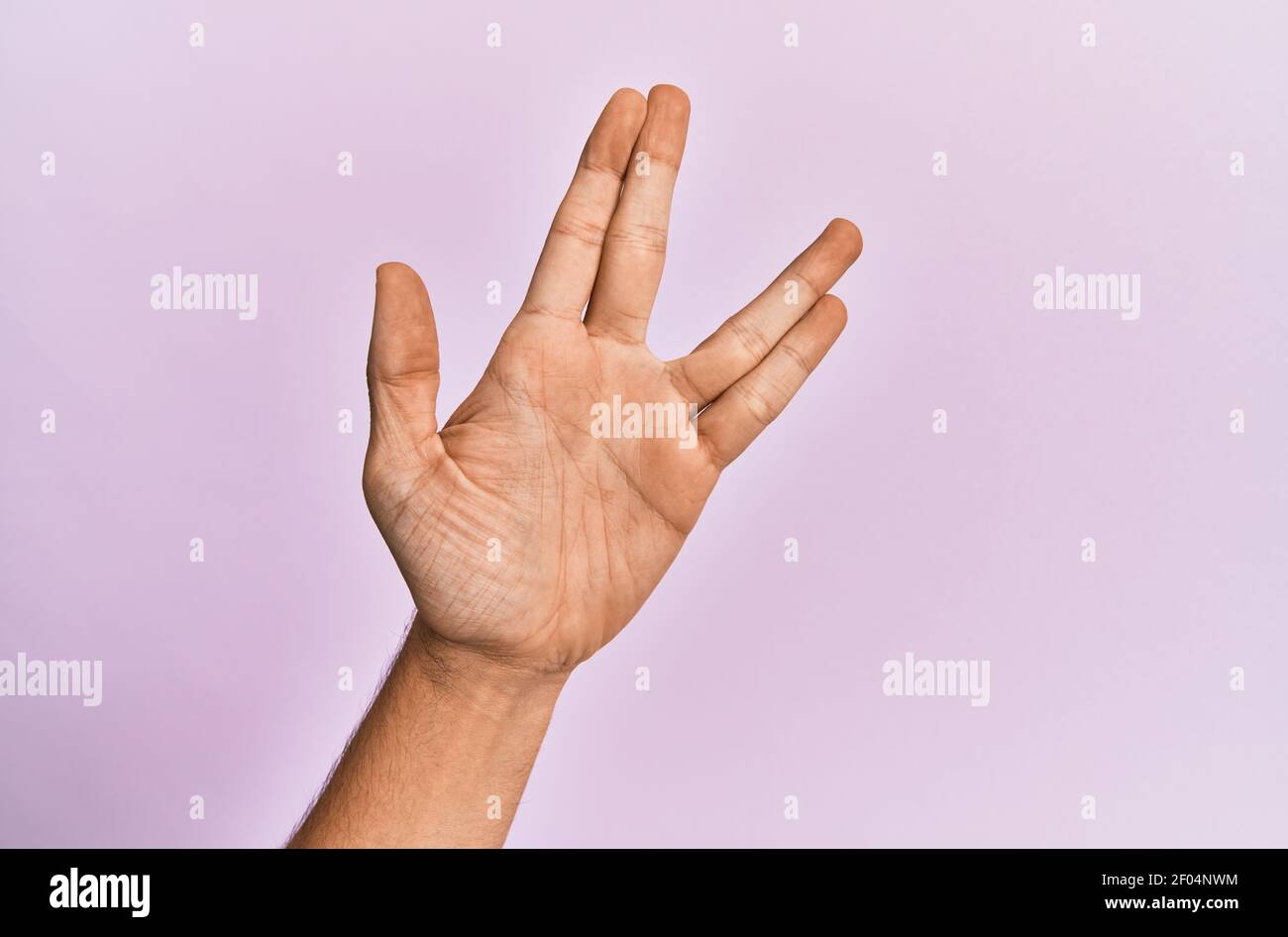Arm and hand of caucasian young man over pink isolated background ...
