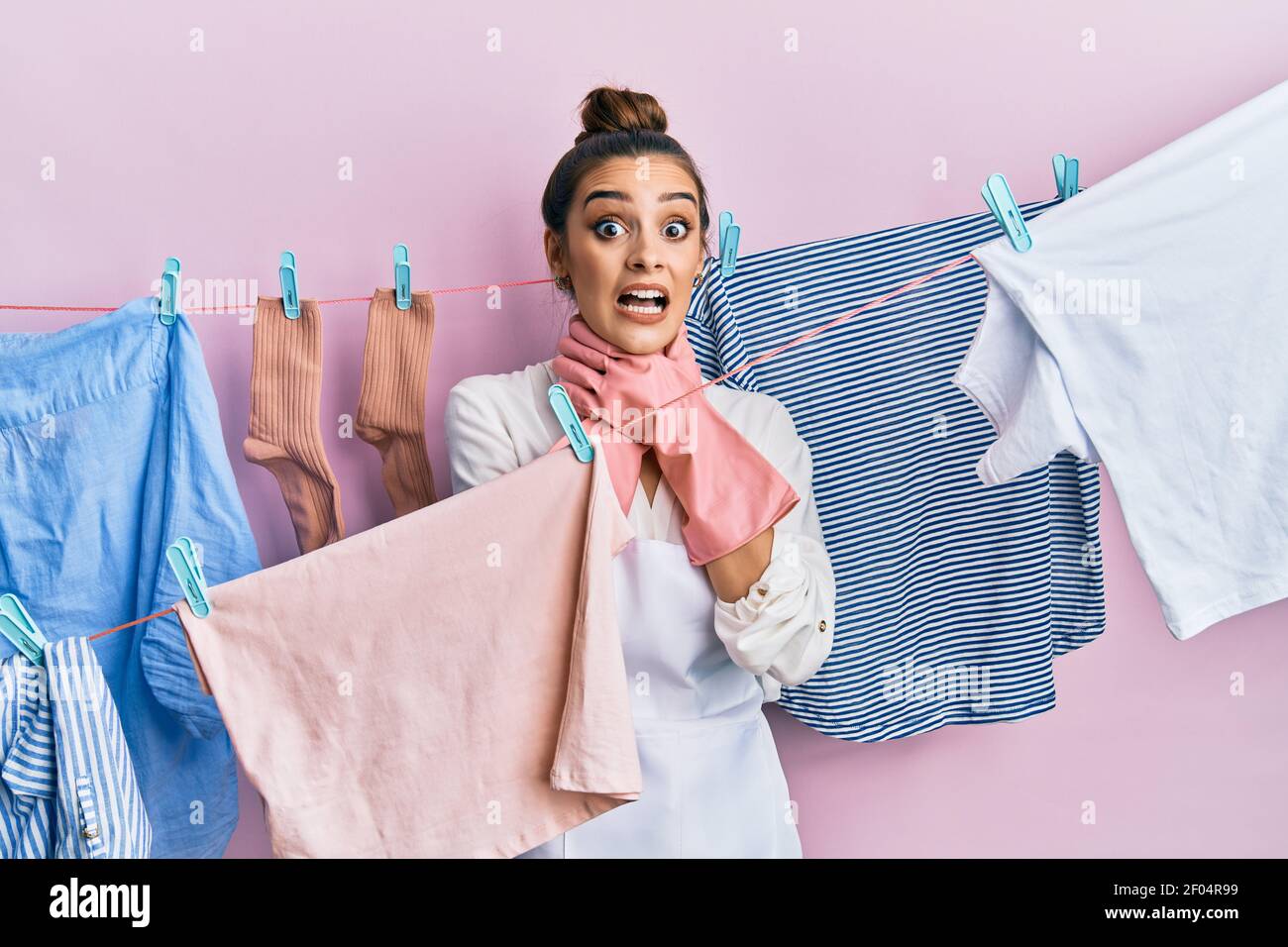 Beautiful brunette young woman washing clothes at clothesline shouting ...