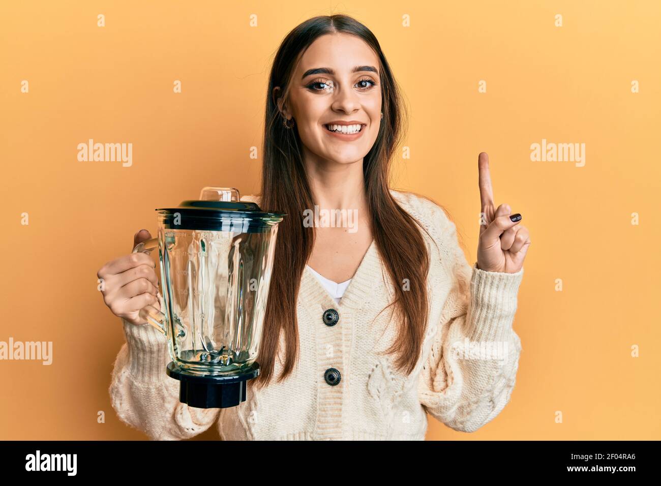 Beautiful brunette young woman holding food processor mixer machine ...