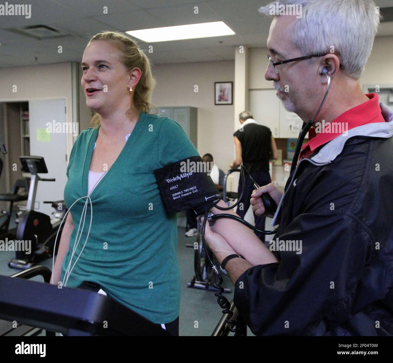 Russ Starrett, RN, takes vital signs of Sarah Batts while she works out ...