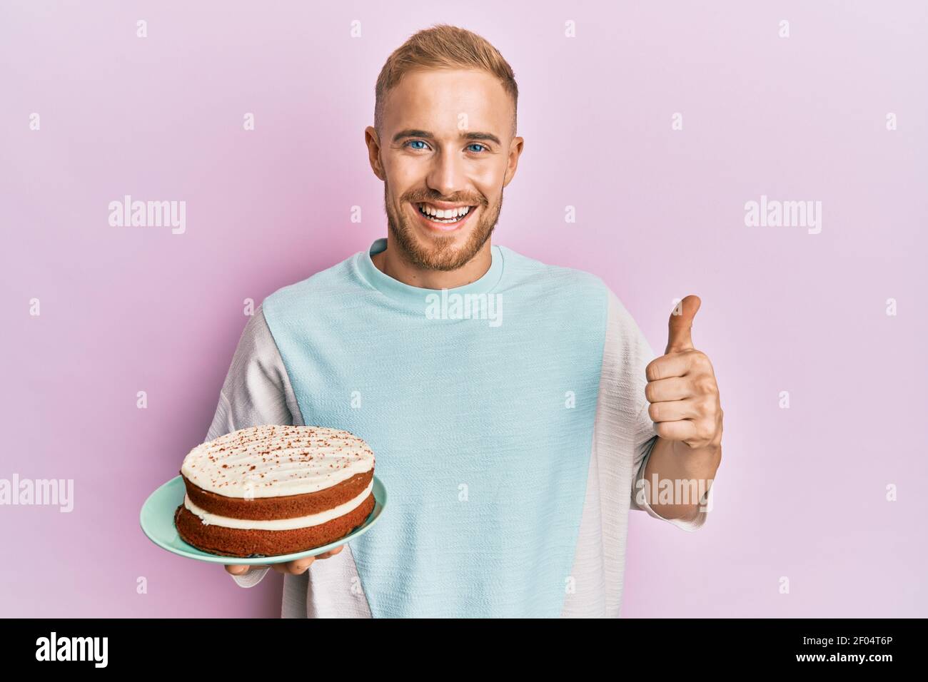 Young caucasian man chef cooking carrot cake smiling happy and positive ...