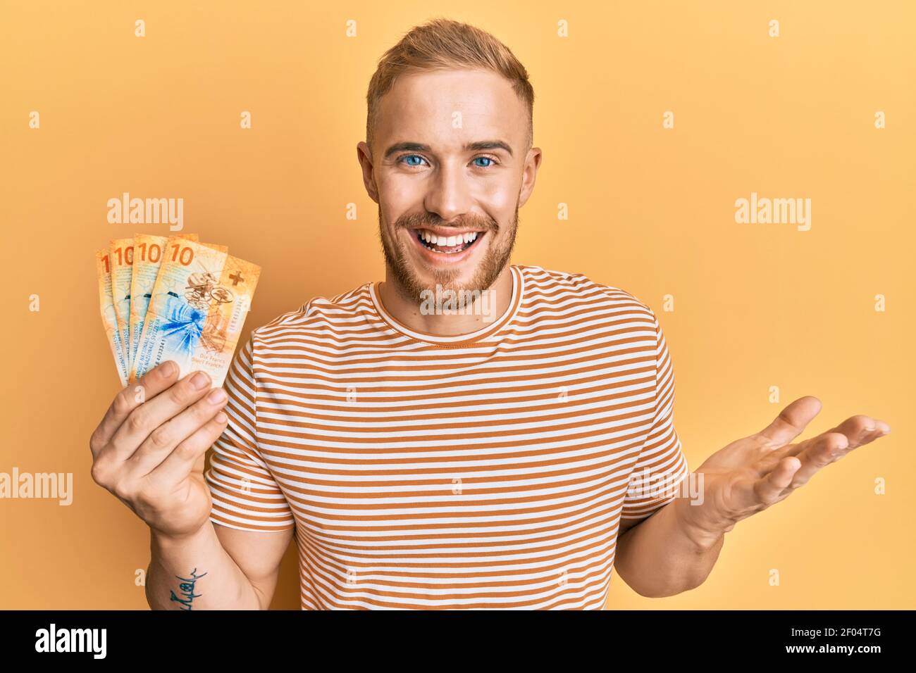 Young caucasian man holding swiss franc banknotes celebrating ...