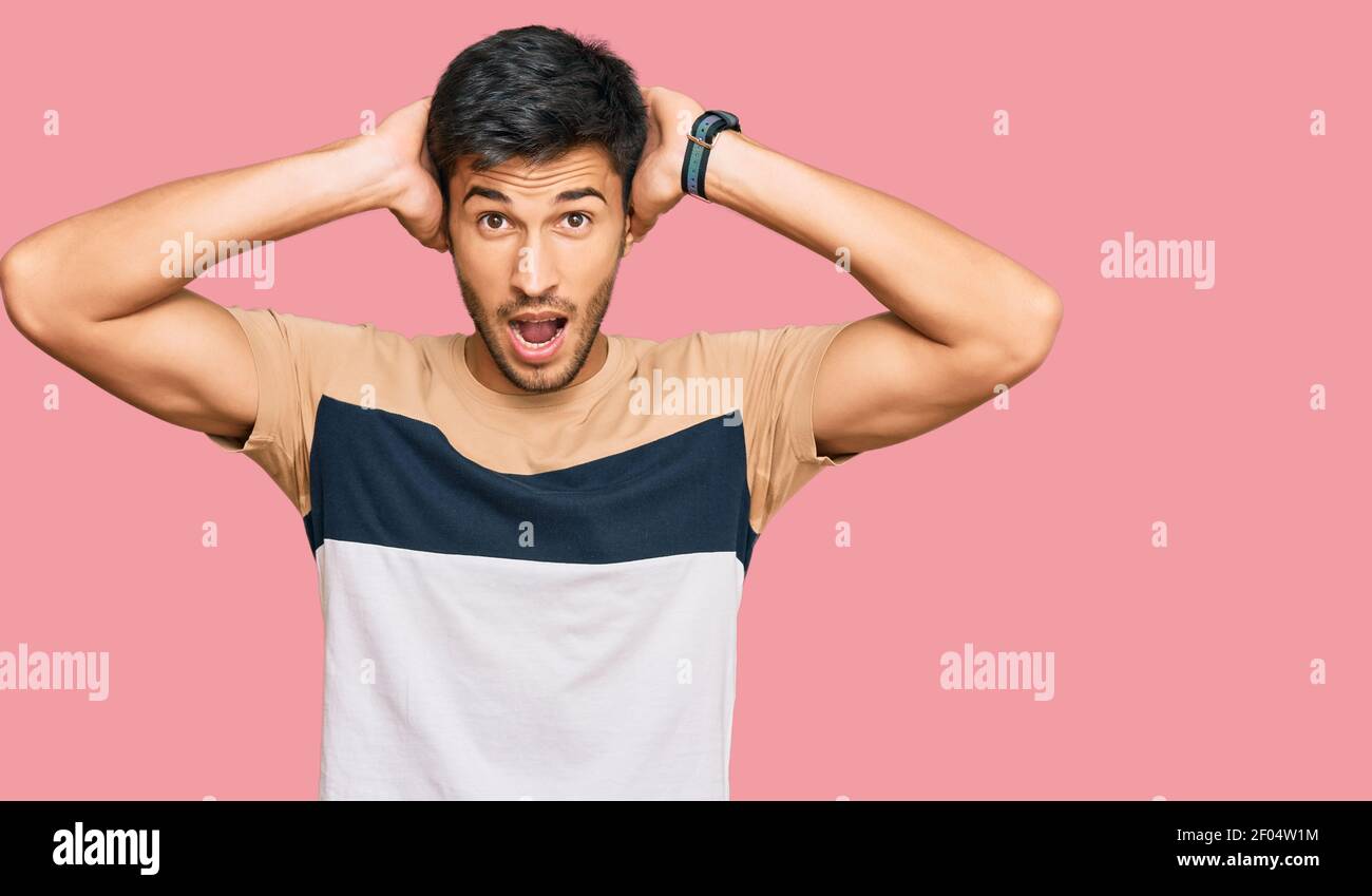Young handsome man wearing casual clothes crazy and scared with hands ...