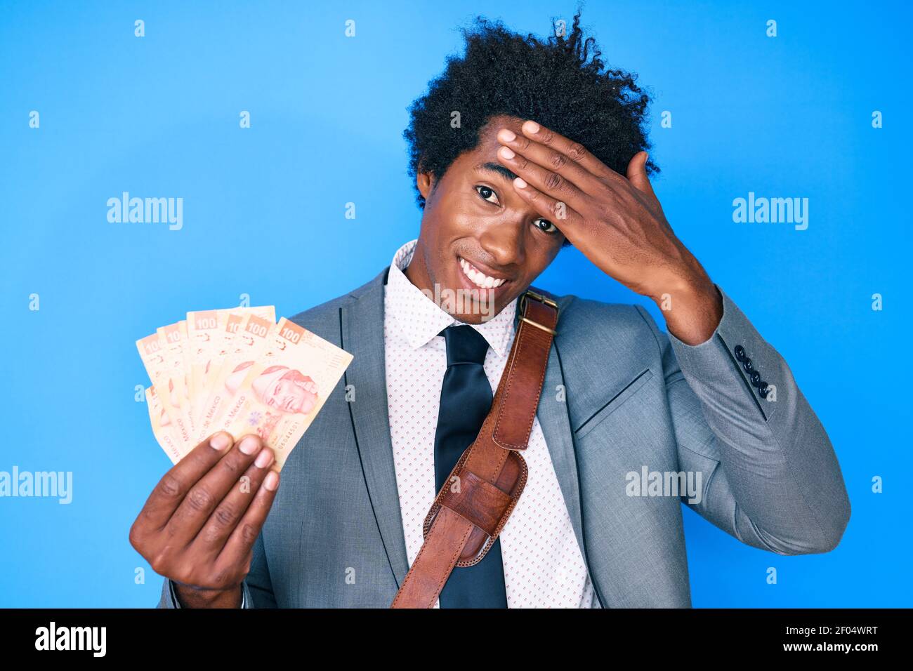 Handsome african american man with afro hair holding mexican pesos ...