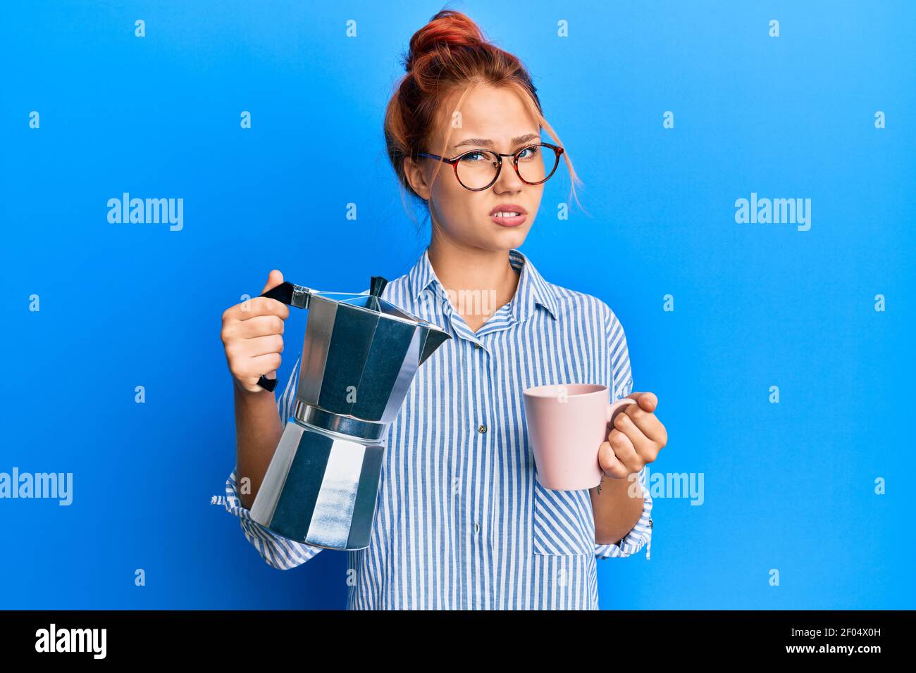 Young redhead woman drinking italian coffee clueless and confused ...
