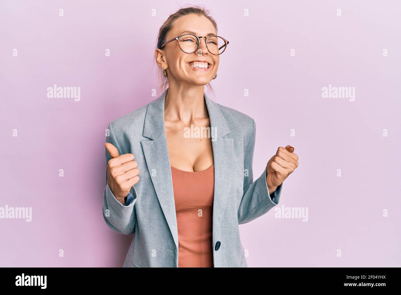 Beautiful caucasian woman wearing business jacket and glasses excited ...