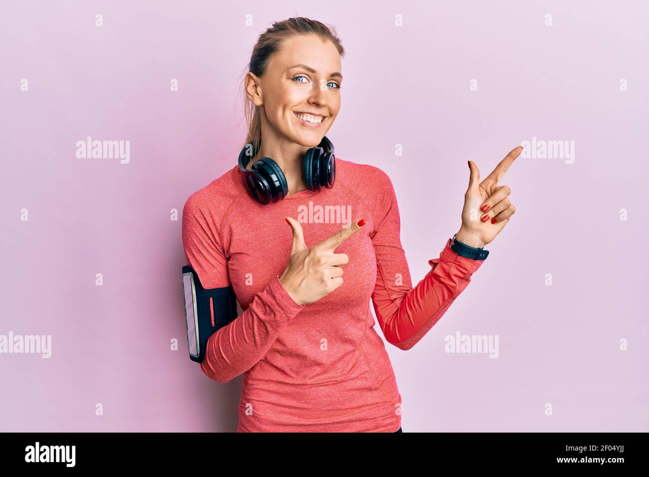 Beautiful caucasian woman wearing sportswear and arm band smiling and ...