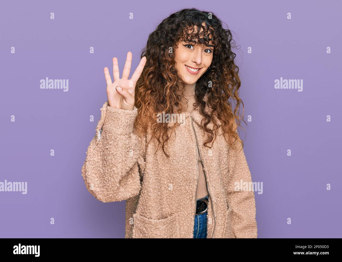 Young hispanic girl wearing winter clothes showing and pointing up with ...