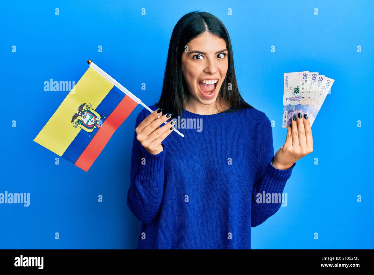 Young hispanic woman holding colombia flag and colombian pesos ...