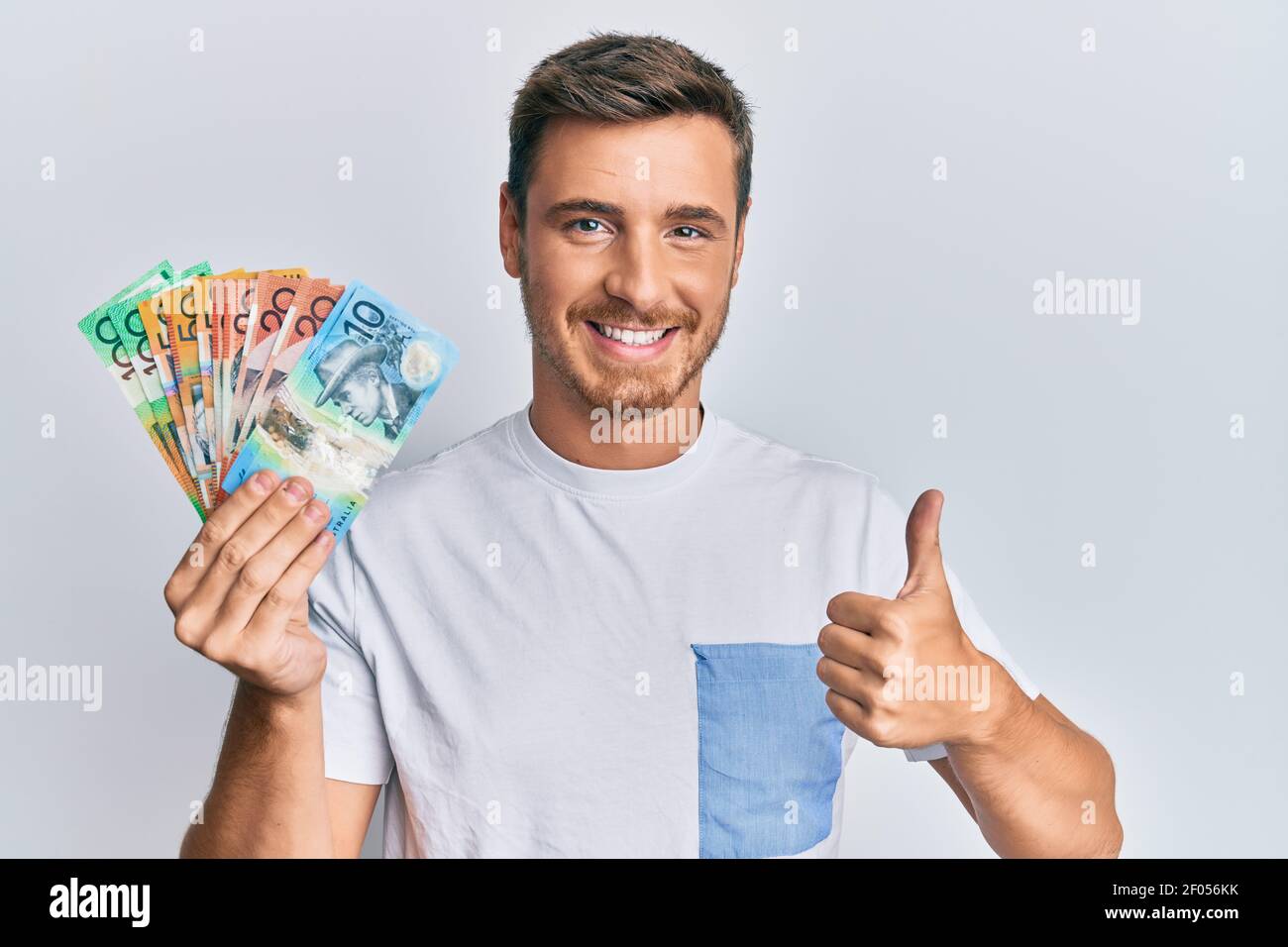 Handsome caucasian man holding australian dollars smiling happy and ...