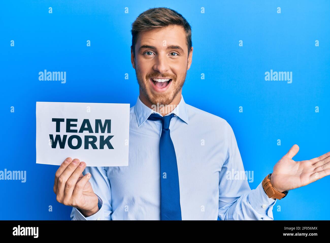 Handsome caucasian business man holding team work banner celebrating ...
