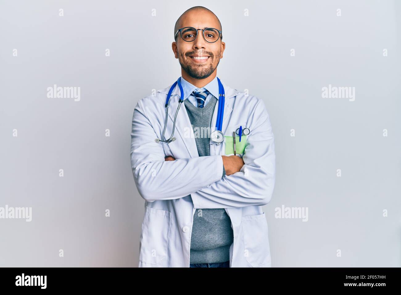 Hispanic adult man wearing doctor uniform and stethoscope happy face ...