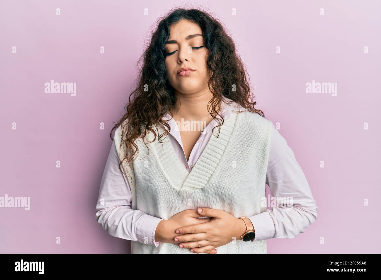 Young brunette woman with curly hair wearing casual clothes with hand ...