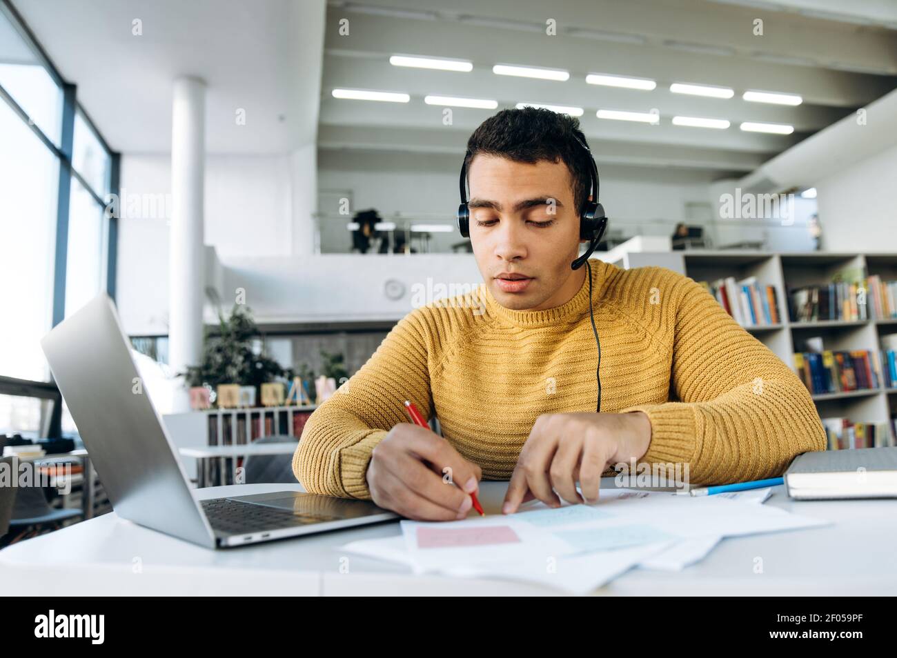 Concentrated hispanic successful freelancer or student sitting at his ...