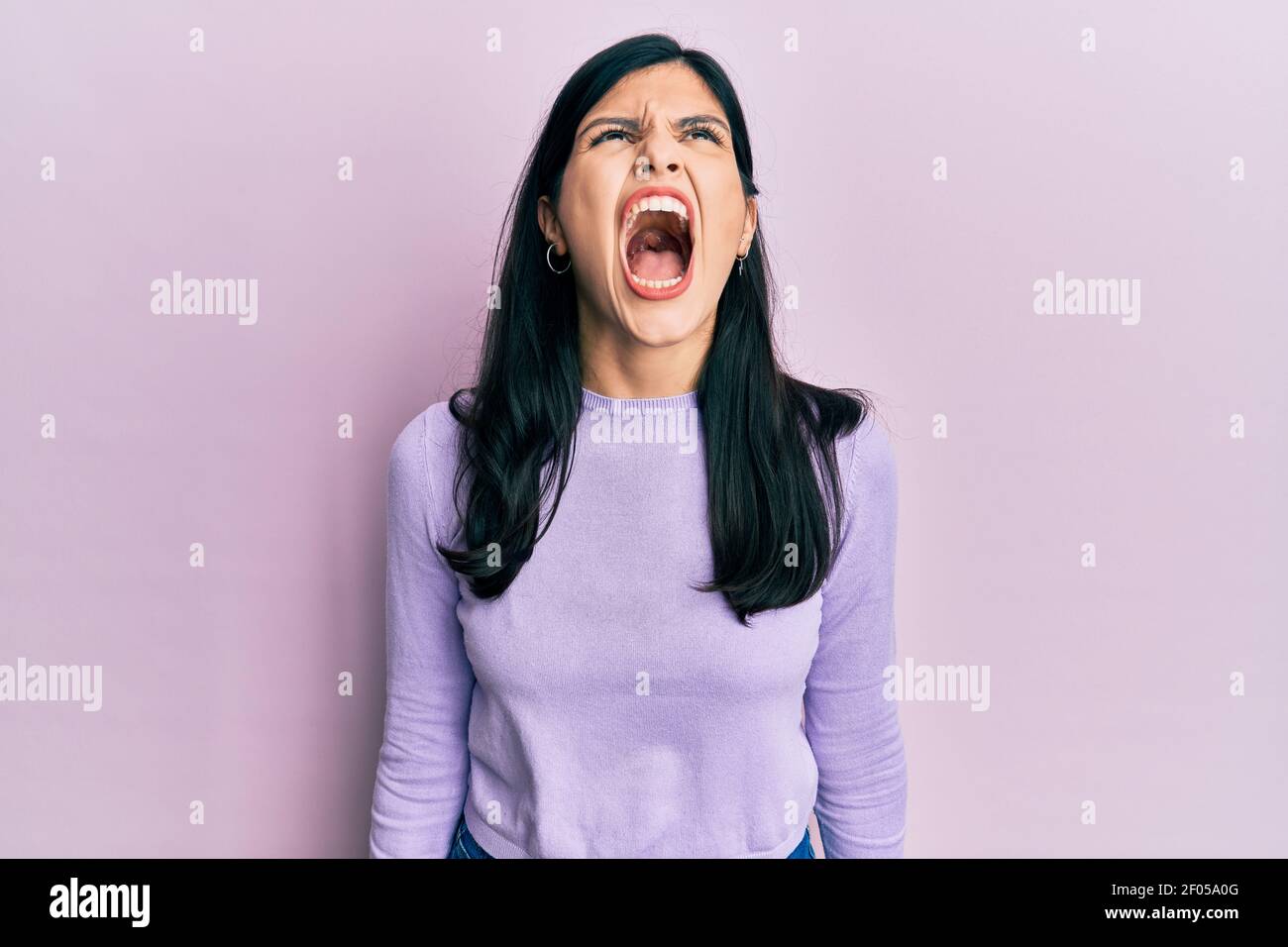 Young hispanic woman wearing casual clothes angry and mad screaming ...