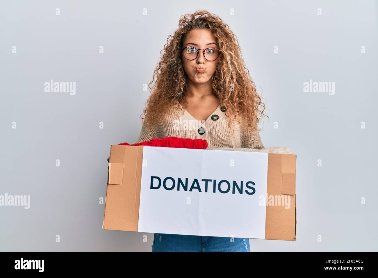 Beautiful caucasian teenager girl volunteer holding donations box ...