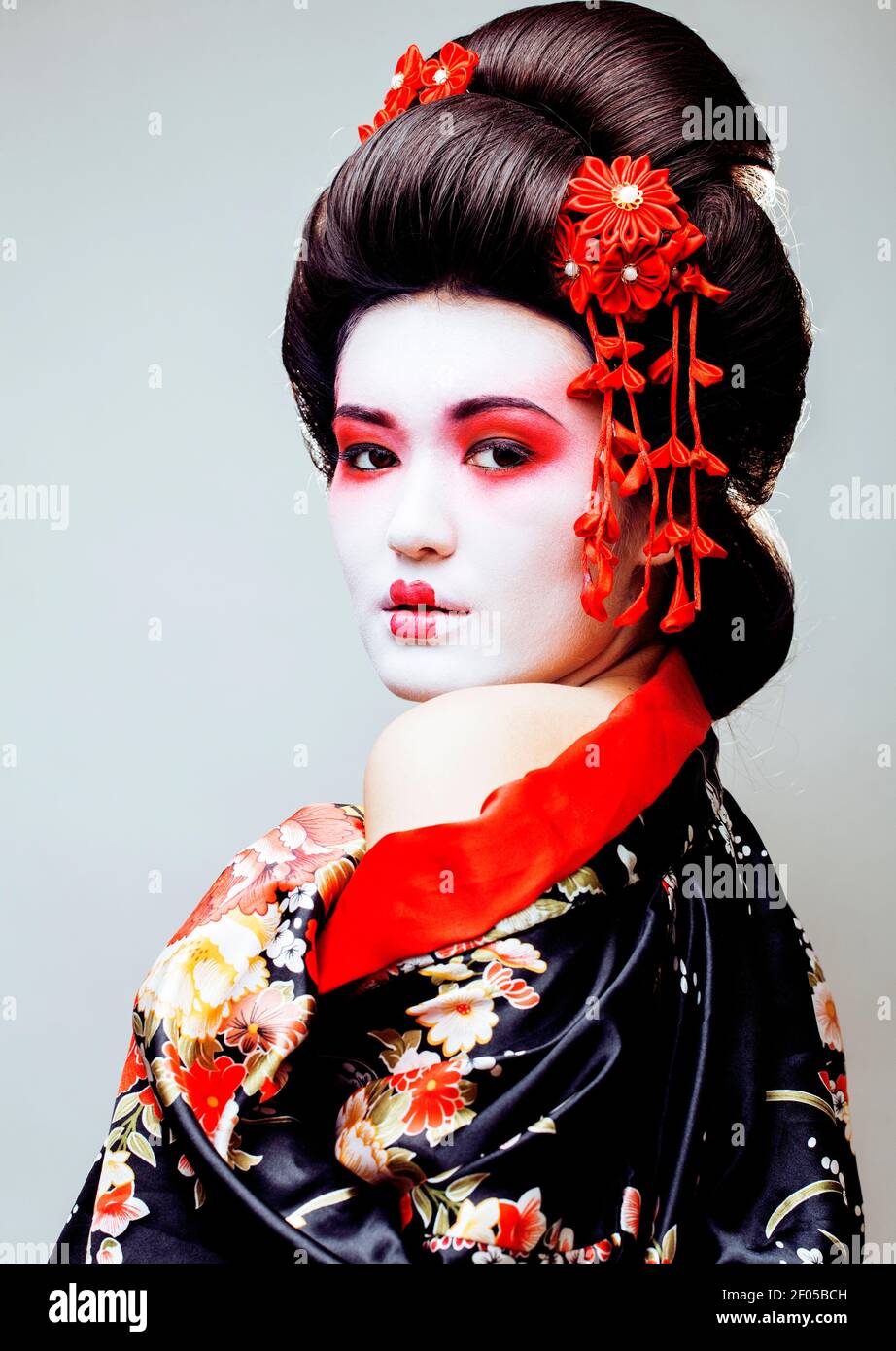 young pretty geisha in black kimono among sakura, asian ethno close up ...