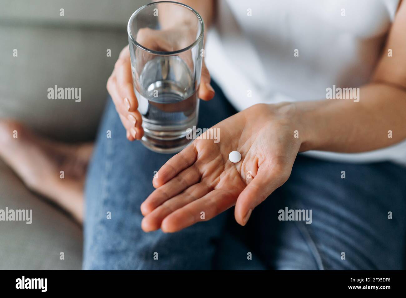 Top view of female hands with pill and water. Pain-relieving pill or ...