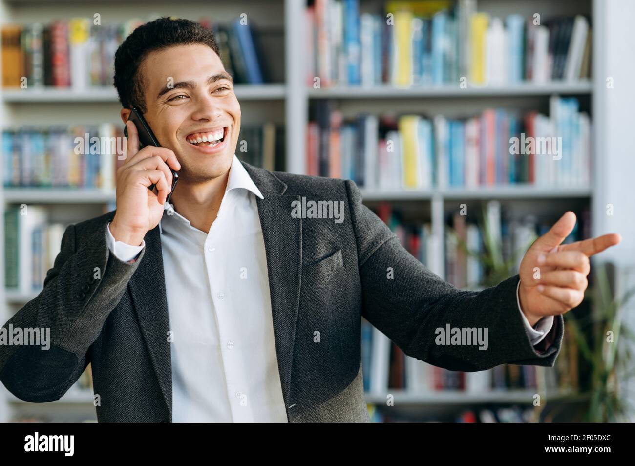 Cheerful employee using smartphone, having a conversation. Happy ...