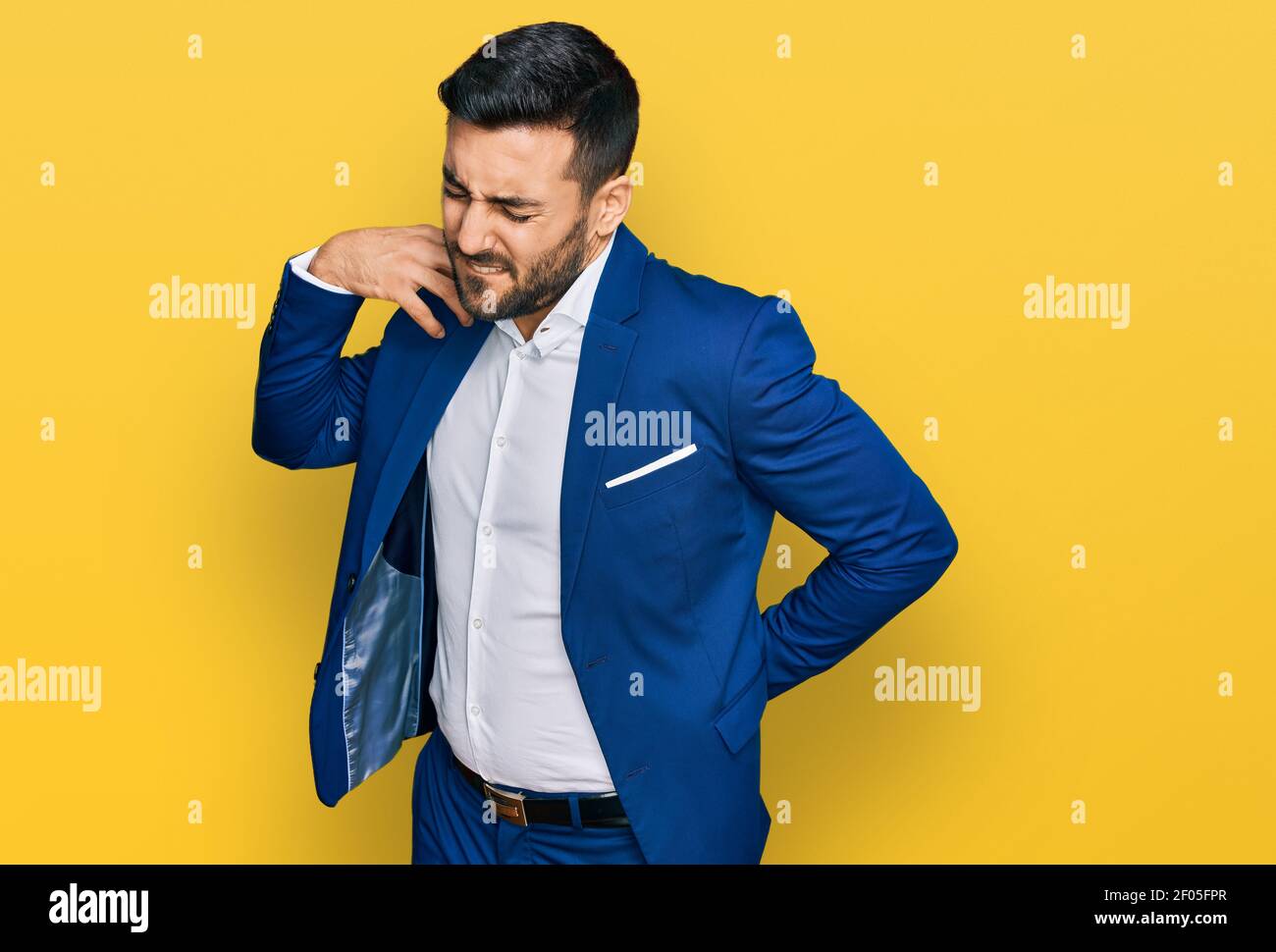 Young hispanic man wearing business jacket suffering of neck ache ...