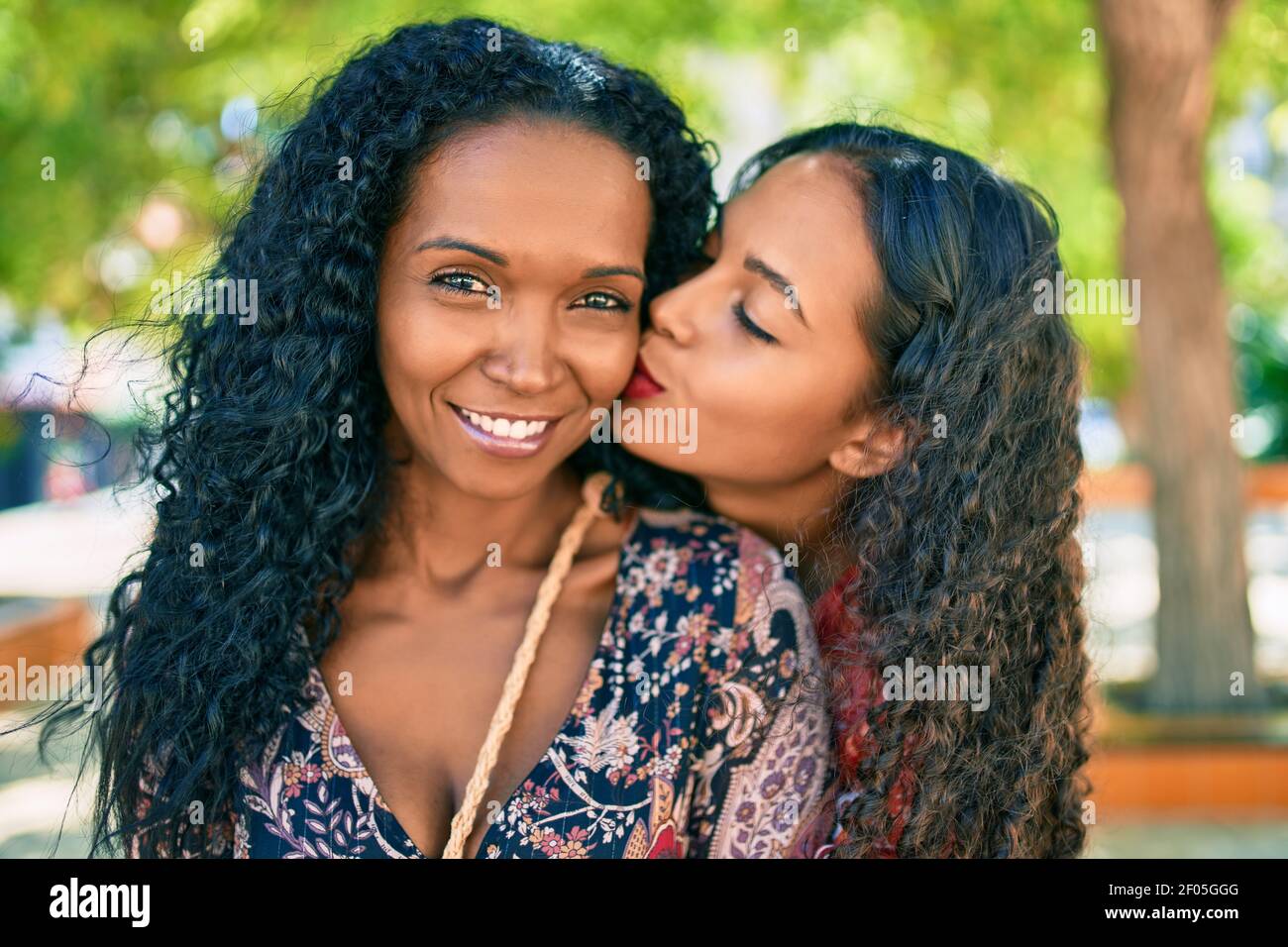 African american mother and daughter smiling happy hugging and kissing at the park Stock Photo ...
