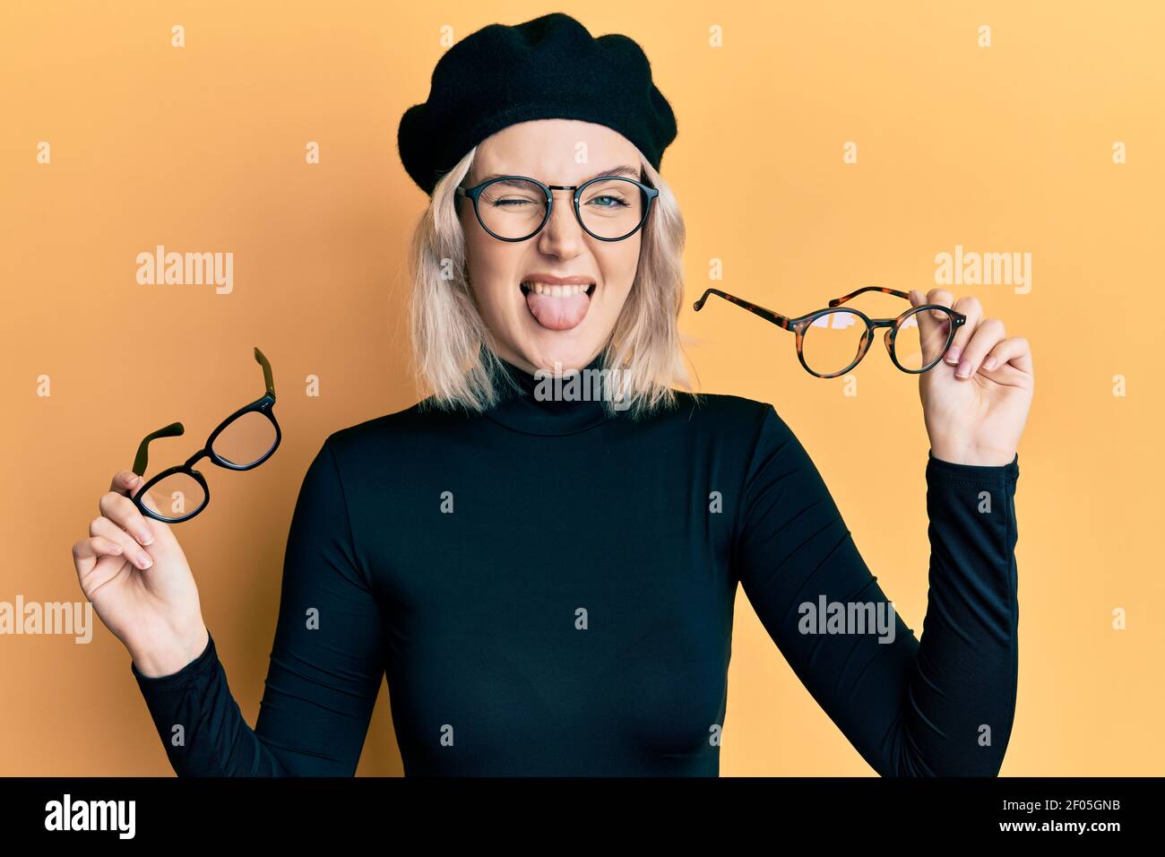 Young blonde girl wearing many glass over face sticking tongue out ...