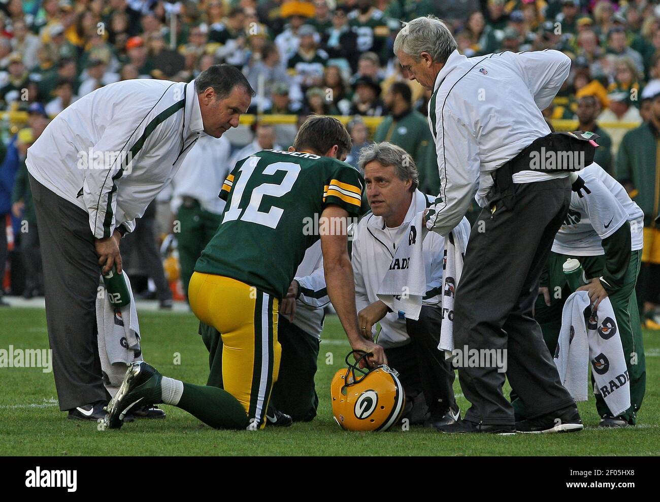 Aaron Rodgers of the Green Bay Packers is looked over after he was ...