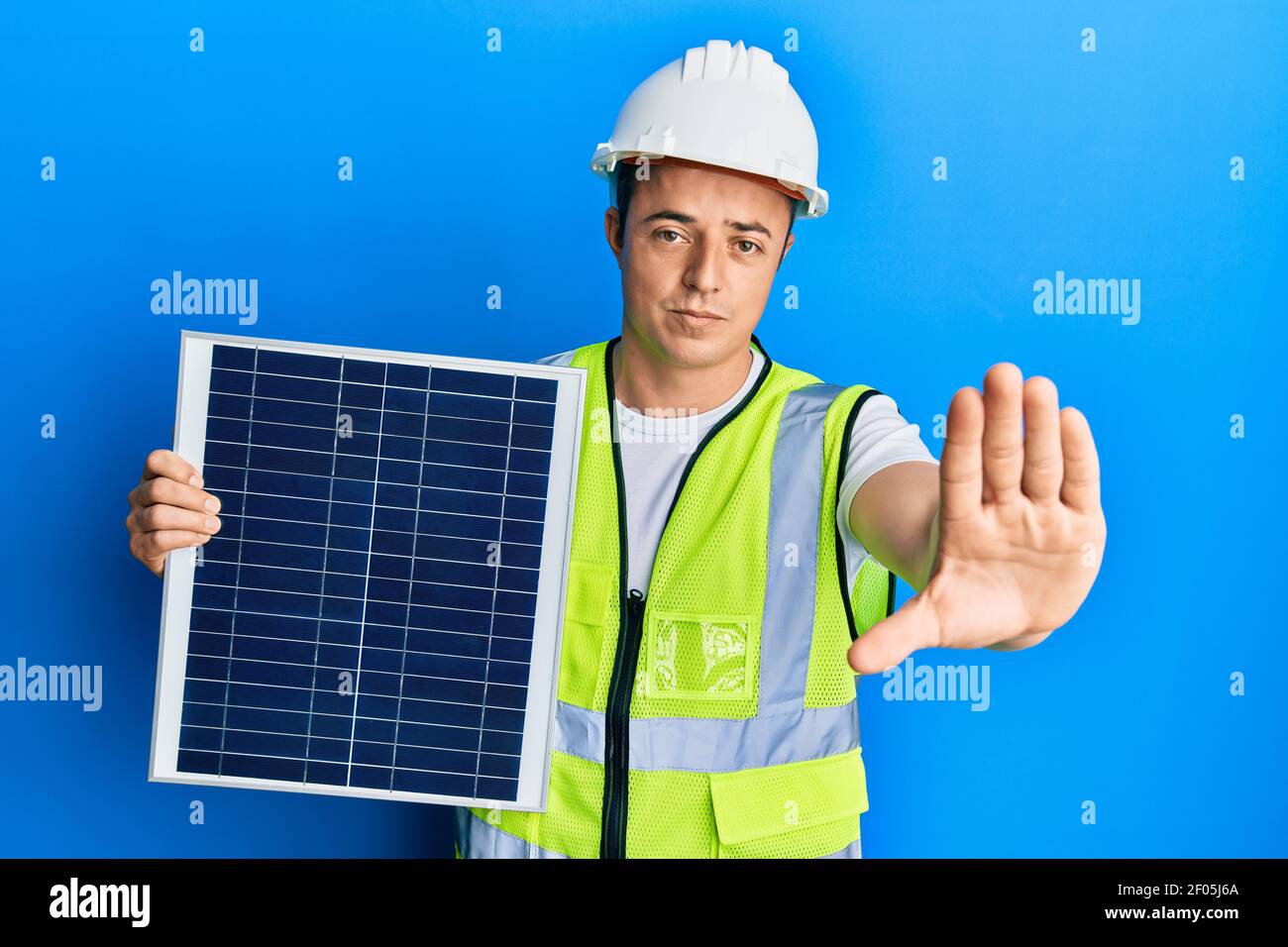 Handsome young man holding photovoltaic solar panel with open hand ...