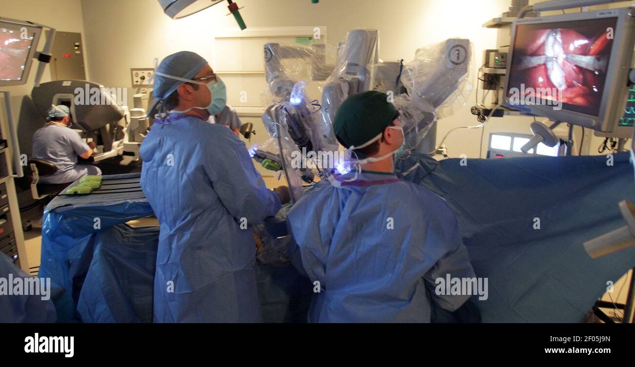 Dr. Adrian G. Dan, far left, sits at the controls of the daVinci ...